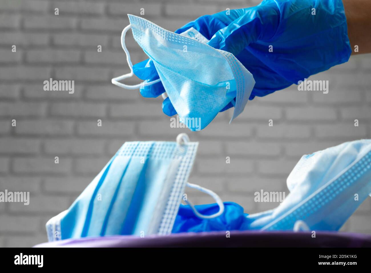 Hand putting used dirty surgical mask to a garbage bin Stock Photo - Alamy