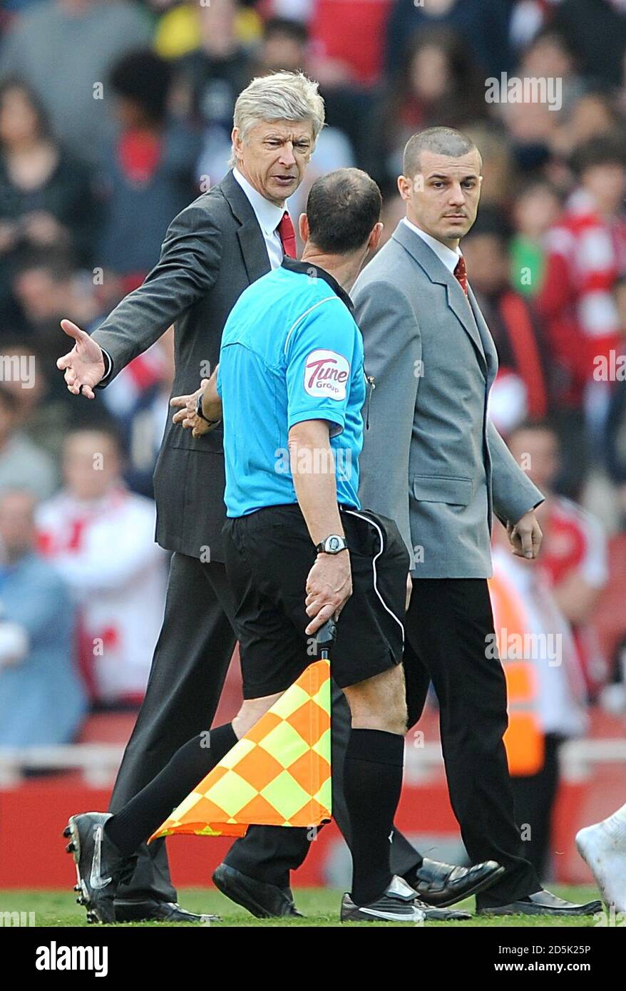 Arsenal manager Arsene Wenger (left) has a word with assistant referee ...