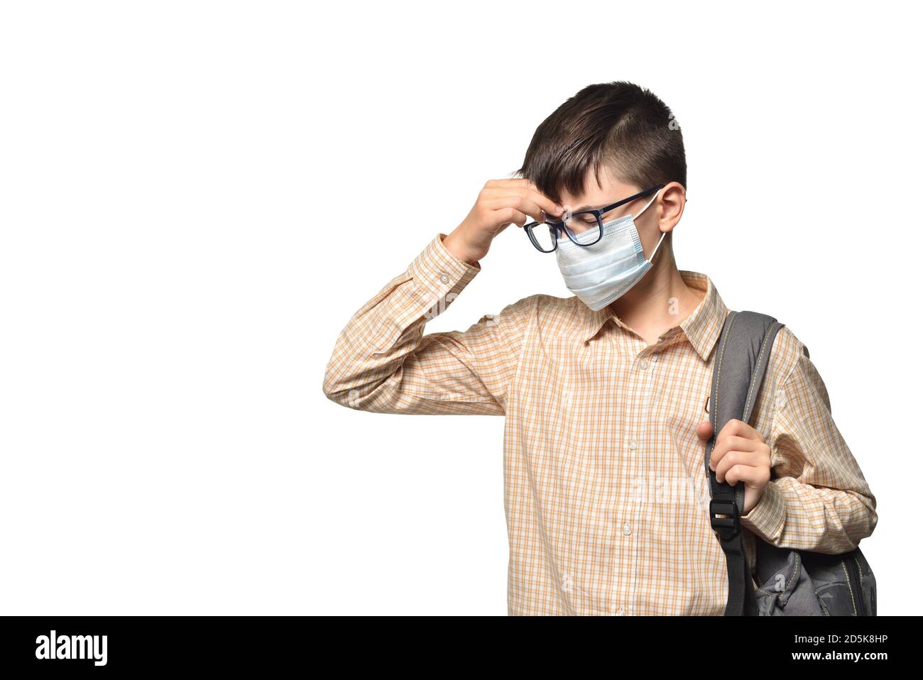 Caucasian white schoolboy wearing a protective mask touching a sick ...