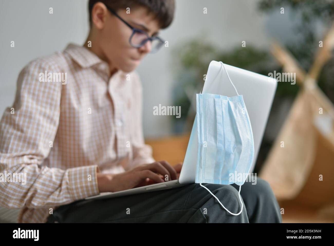 Protective mask on laptop monitor and stressed teenager Stock Photo - Alamy