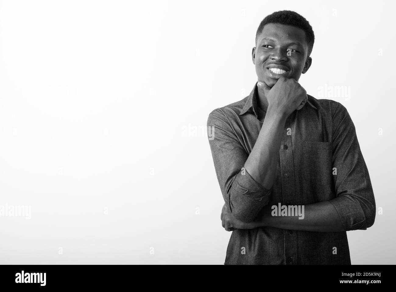 Studio shot of young happy black African man smiling while thinking ...