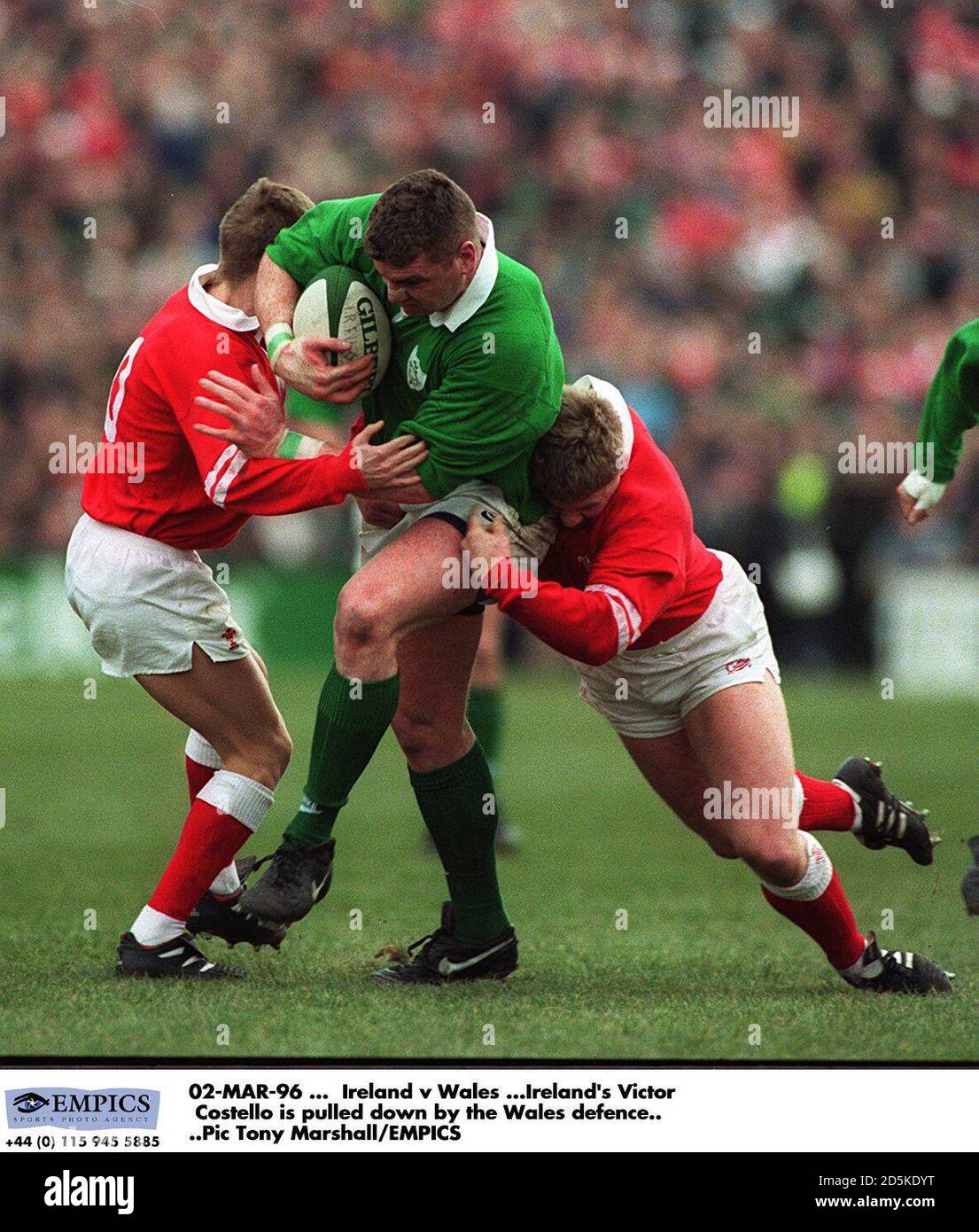 Ireland's Victor Costello is pulled down by the Wales defence Stock ...