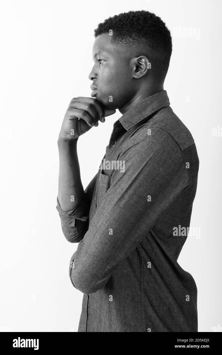 Profile view of young black African man thinking against white ...