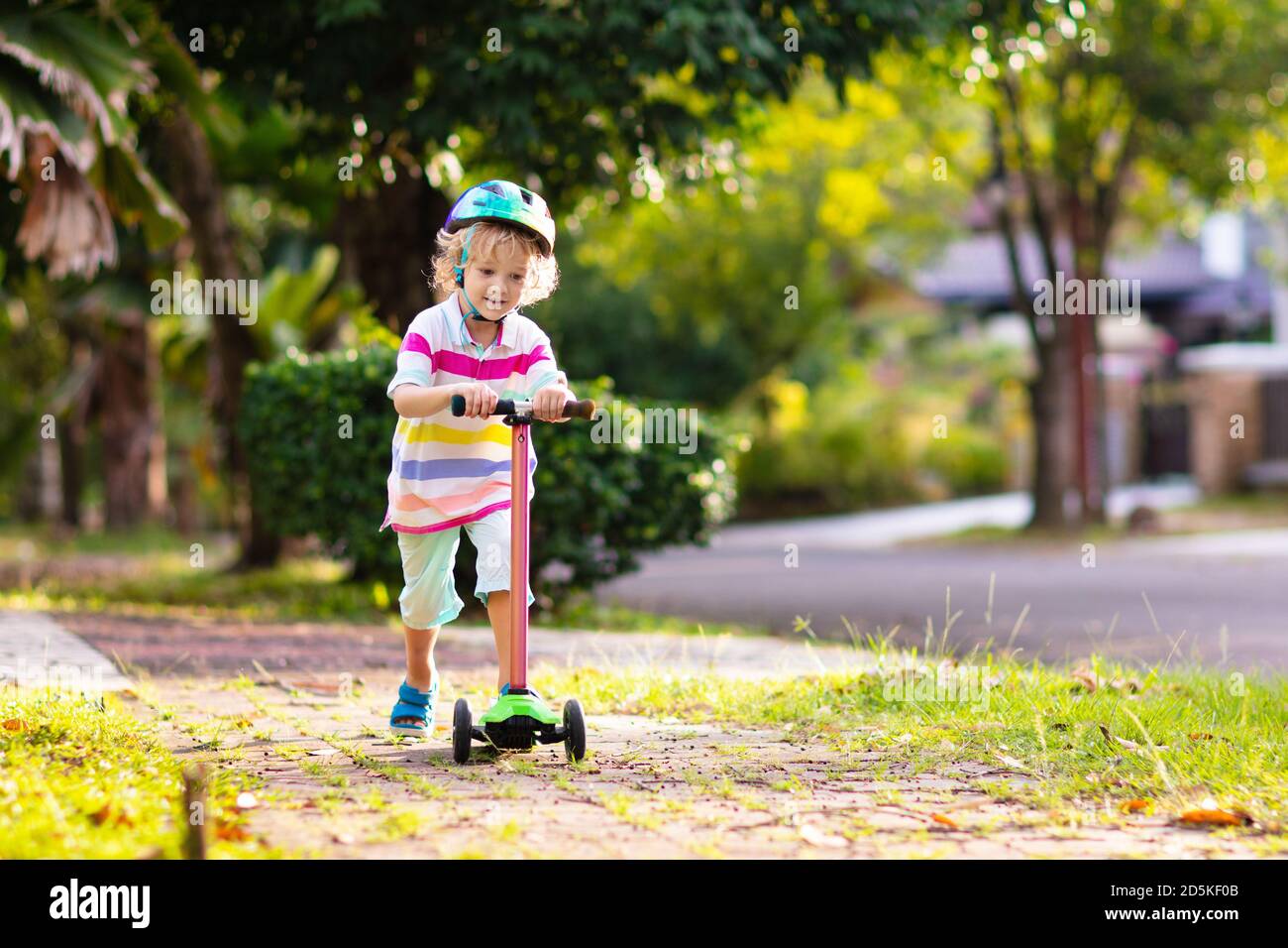 Little boy riding scooter. Kids ride kick board. Child playing on ...
