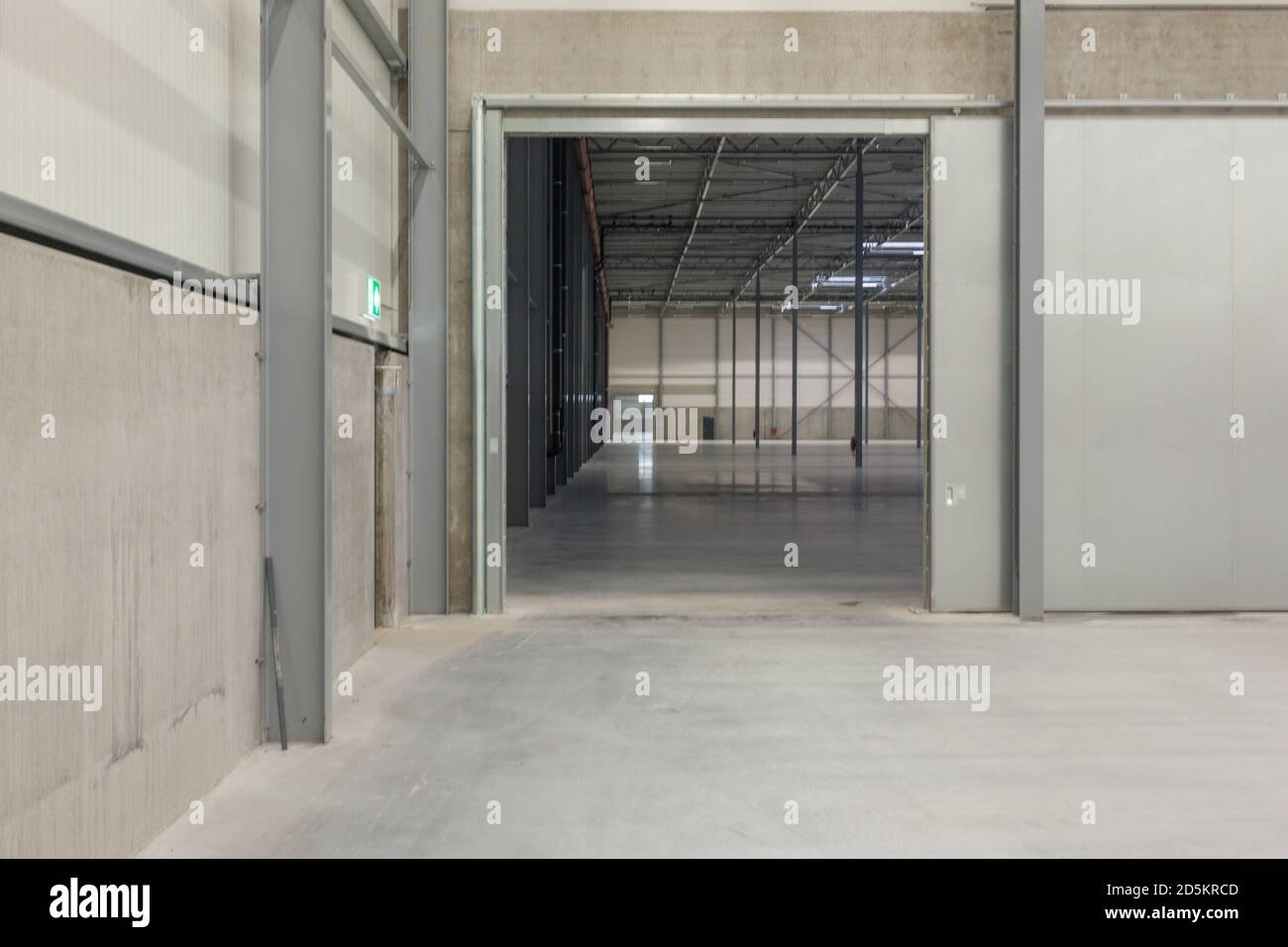 View inside a clean and new warehouse looking through a door to another ...