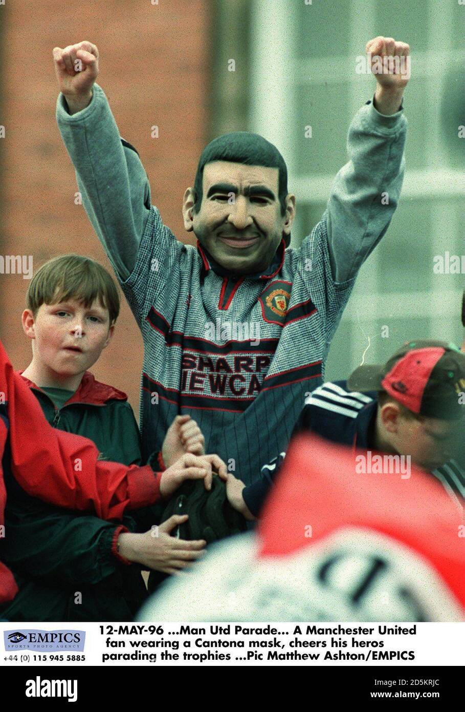 A Manchester United fan with a Eric Cantona mask on cheers his heros ...