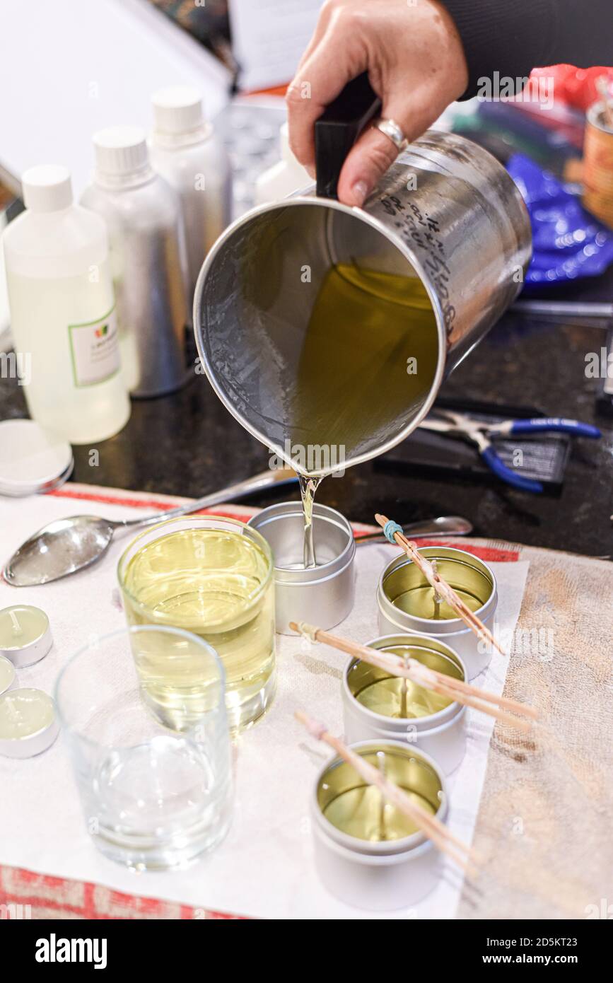 Creative occupation of candle making showing the pouring of liquid wax ...