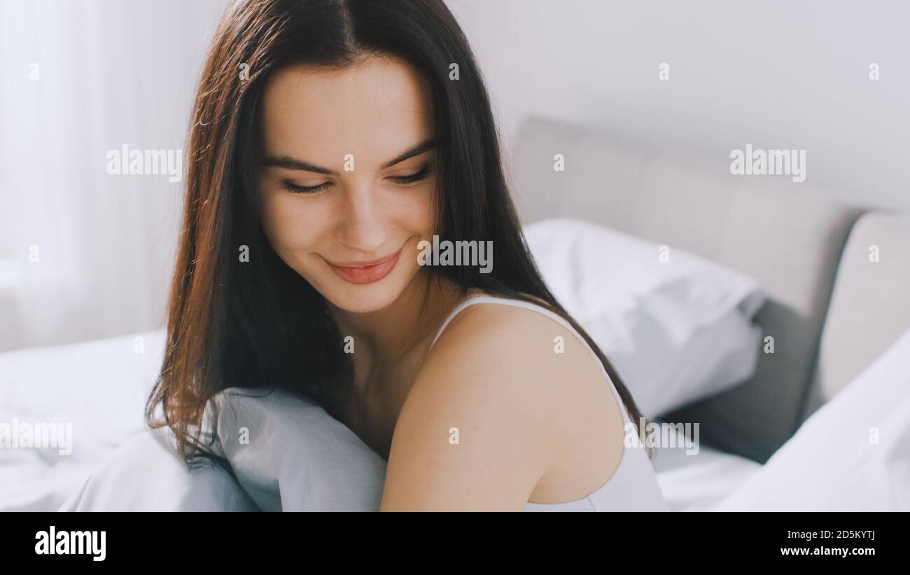 Beautiful Brunette Slowly Waking Up In The Morning Sits Up On The Bed