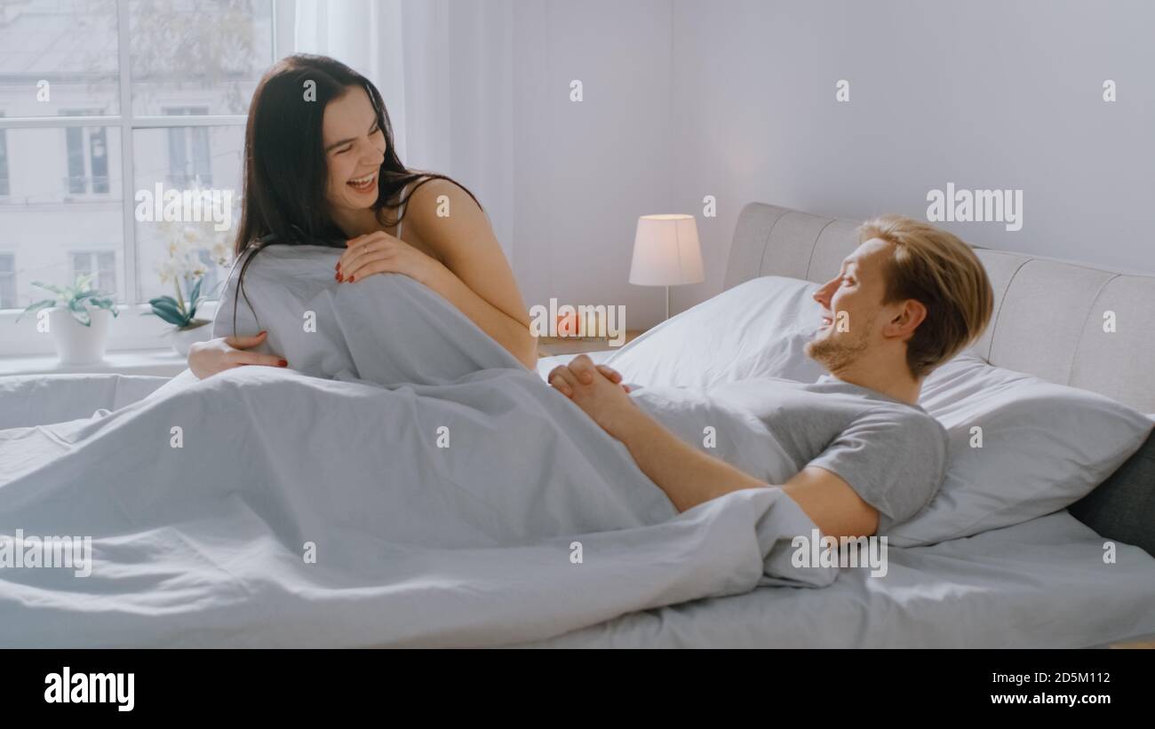 Cute Young Couple Cuddling and Playing in the Bed, Morning Sun Shines ...