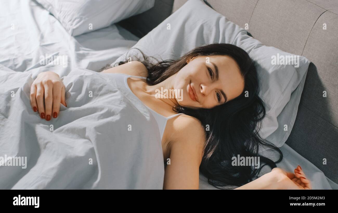 Beautiful Brunette Slowly Waking up in the Morning, Lying in a Bed ...