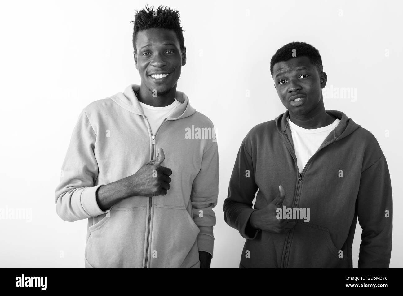 Two young happy black African friends smiling while giving thumb up ...