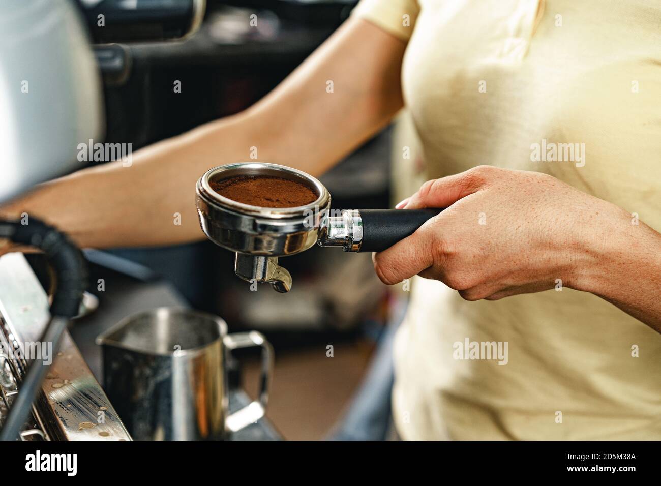 Woman coffee shop worker preparing coffee on professional coffee ...