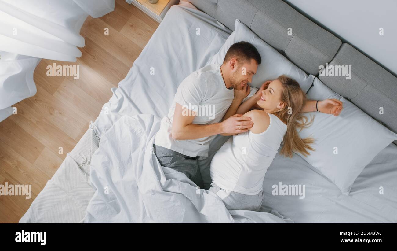 Happy Young Couple Cuddling Together in the Bed, Young Woman is ...