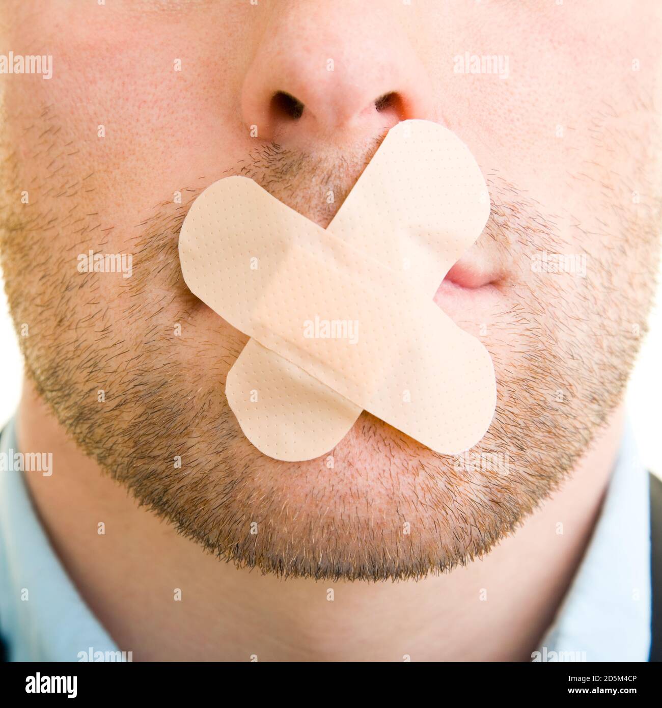 Young man in a suit with a plaster on his mouth Stock Photo - Alamy
