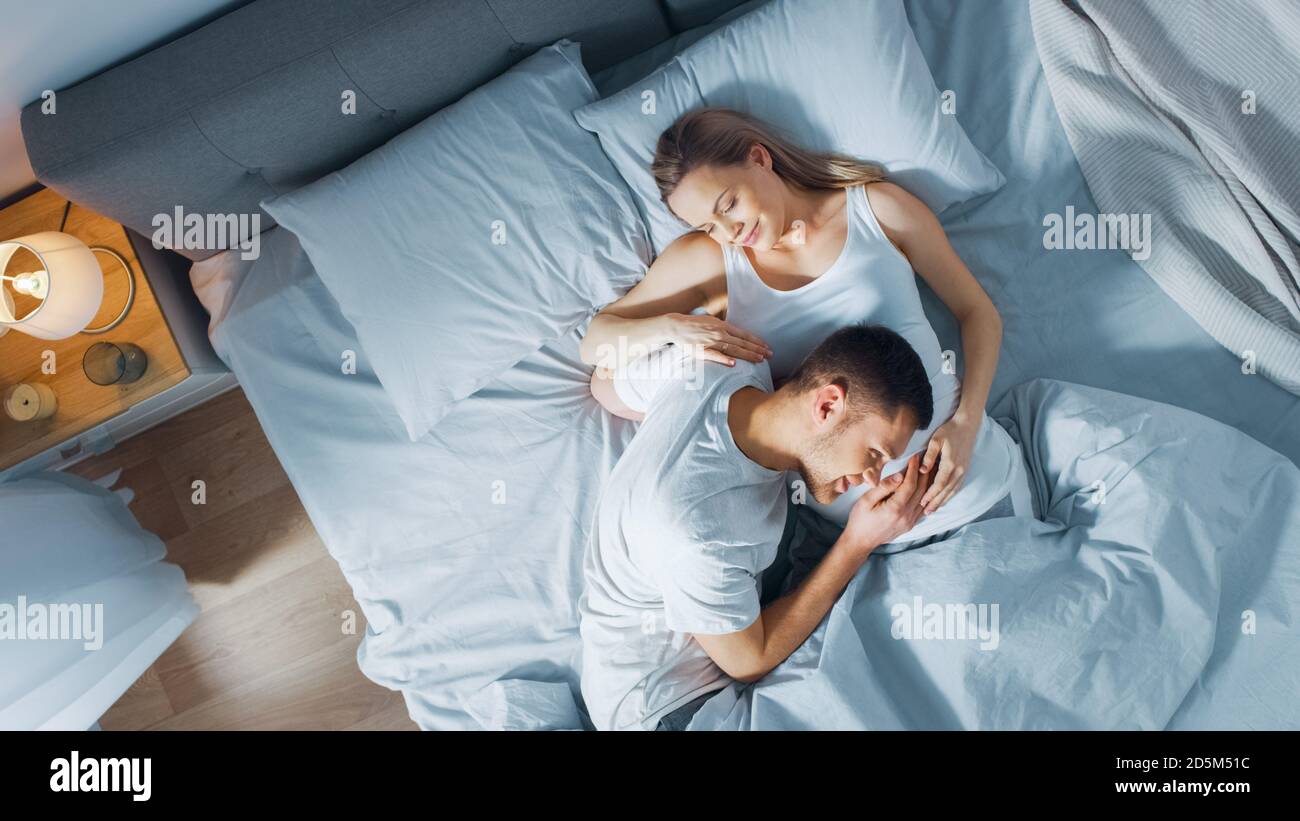 Happy Young Couple Cuddling Together in the Bed, Young Woman is ...