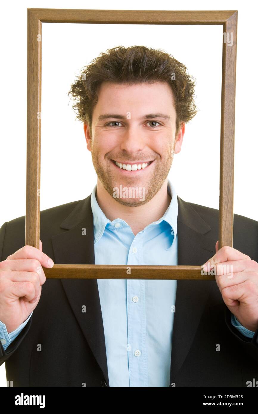 Young man in a suit looks through an empty wooden frame Stock Photo - Alamy
