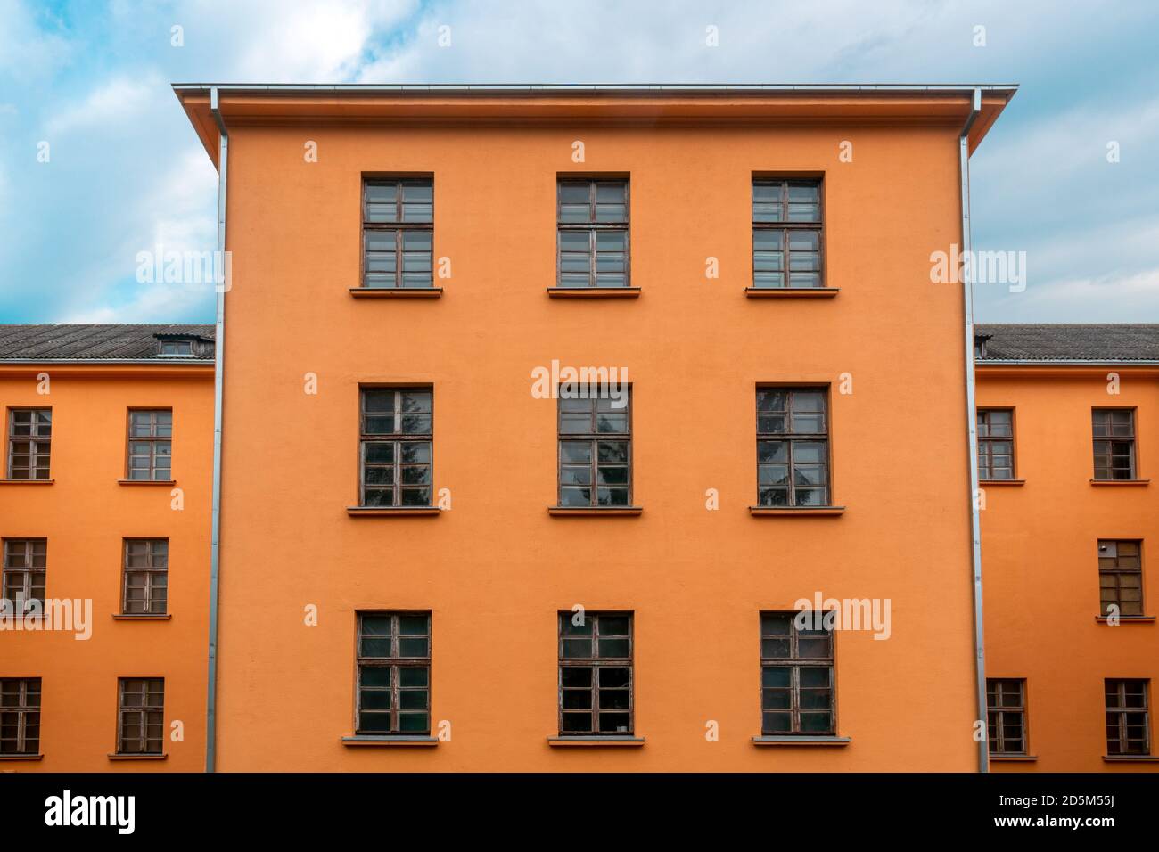 Facade of orange industrial building with cloudy sky background Stock ...