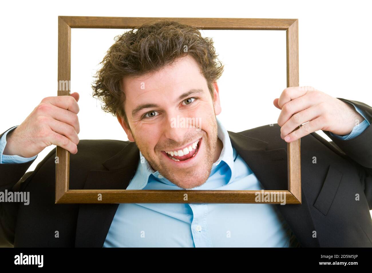 Young man in a suit looks through an empty wooden frame Stock Photo - Alamy
