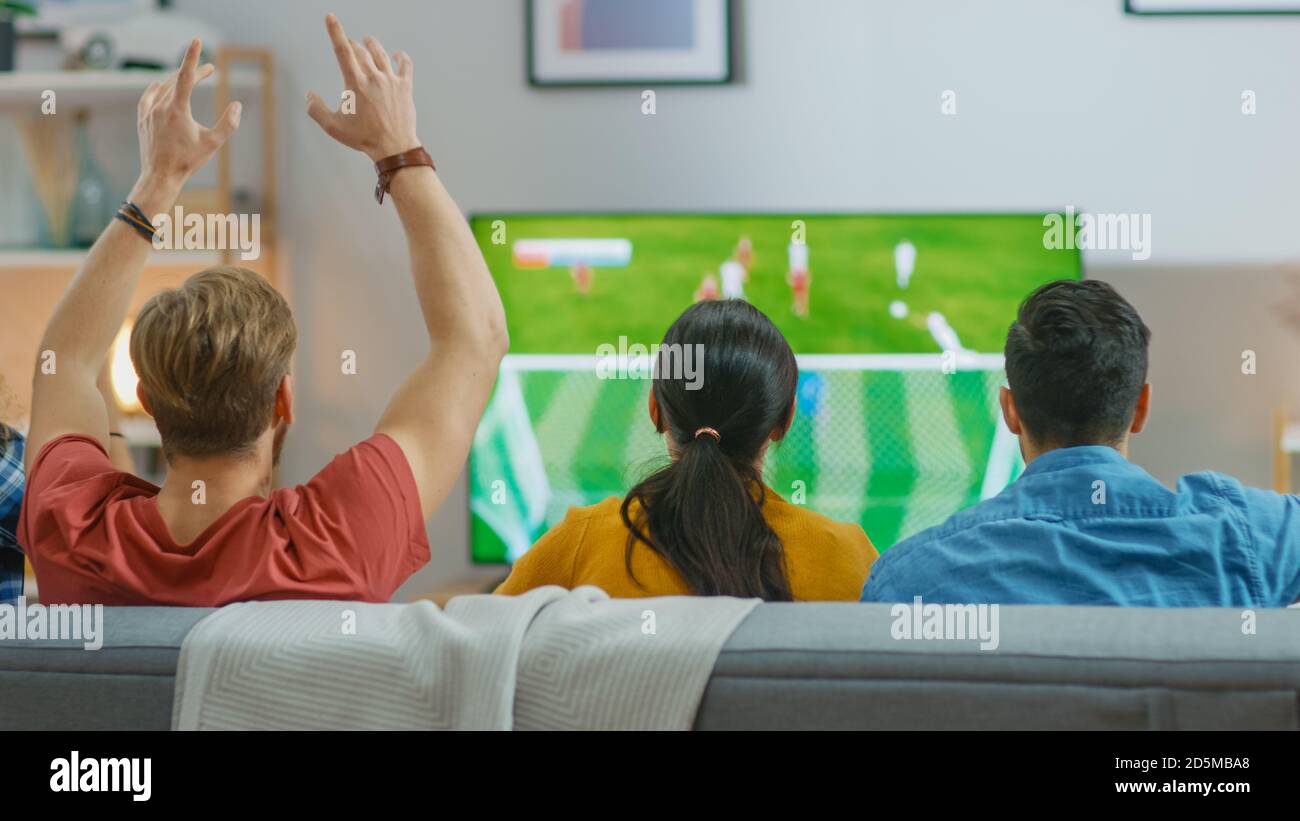 At Home Diverse Group of Sports Fans Sitting on a Couch Watching ...