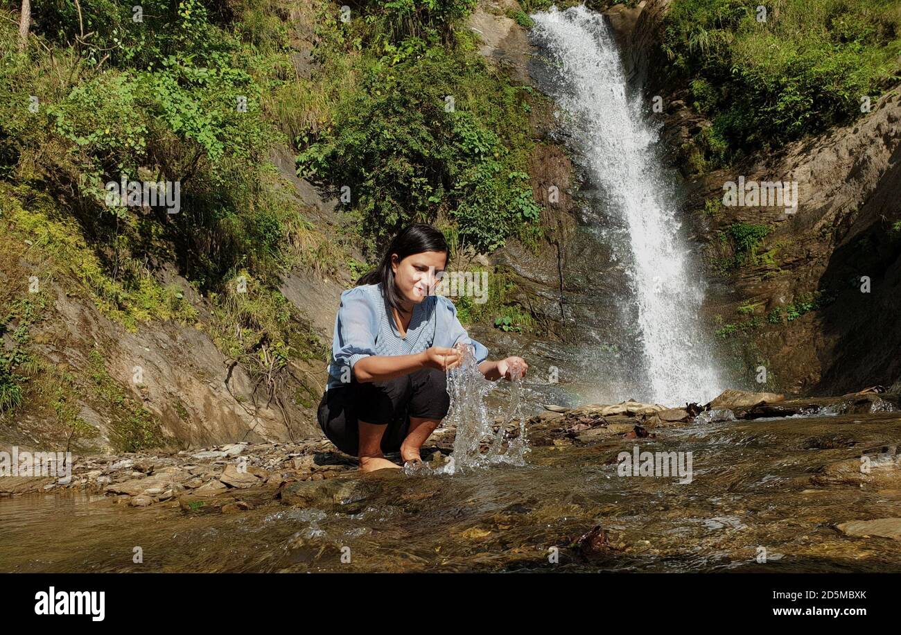 Rolpa, Nepal. 14th Oct, 2020. A woman enjoys at Richibi waterfall, a ...