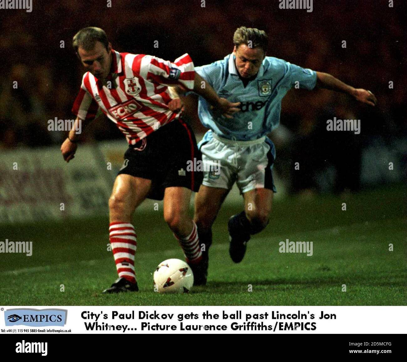 Manchester City's Paul Dickov gets the ball past Lincoln's Jon Whitney ...