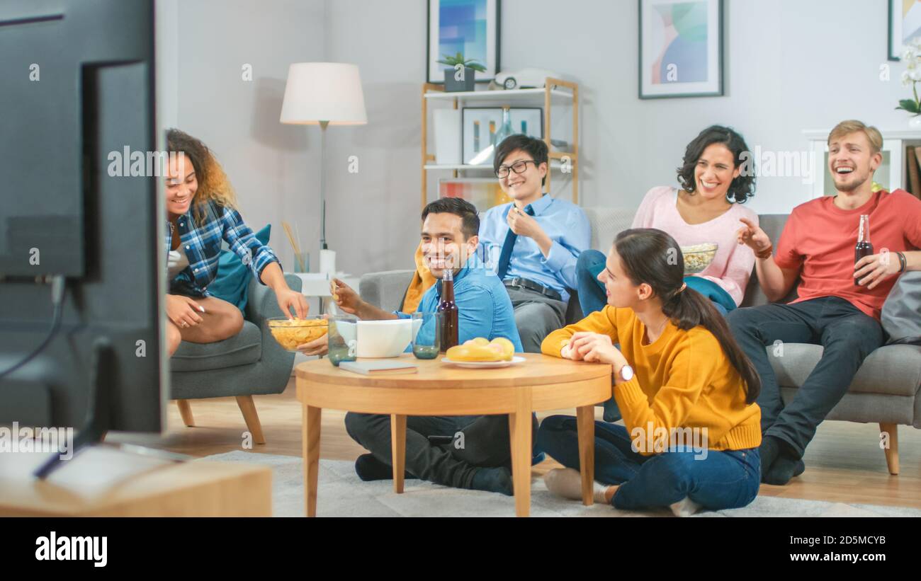 At Home Diverse Group Friends Watching TV Together, Eating Snacks and ...