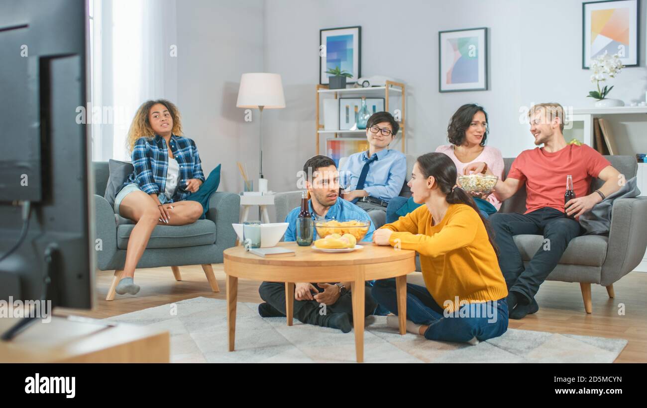 At Home Diverse Group Friends Watching TV Together, Eating Snacks and ...