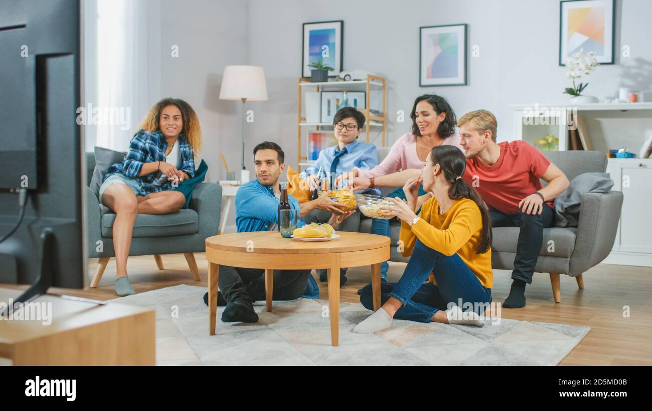 At Home Diverse Group Friends Watching TV Together, Eating Snacks and ...