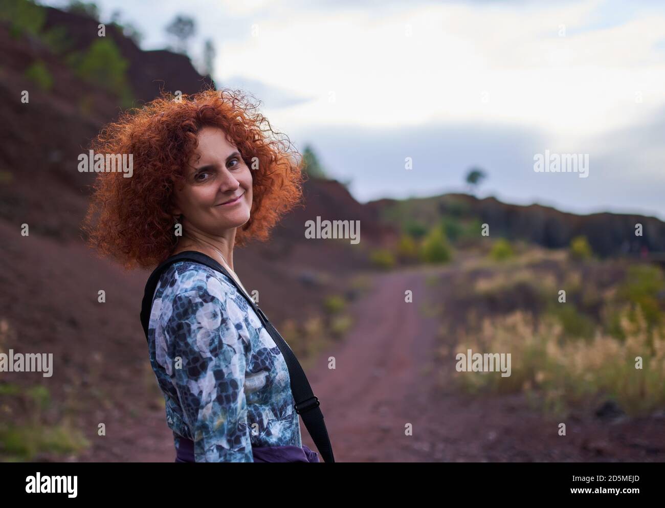 Candid portrait of a beautiful redhead woman inside the caldera of an ...