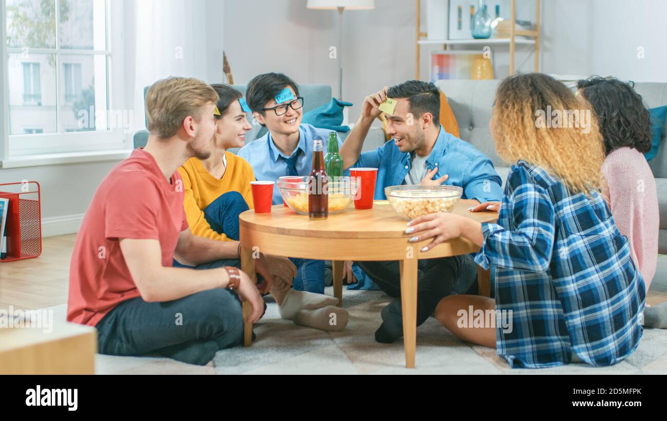 In the Living Room Diverse Group of Fun Loving Friends Playing "Who am ...