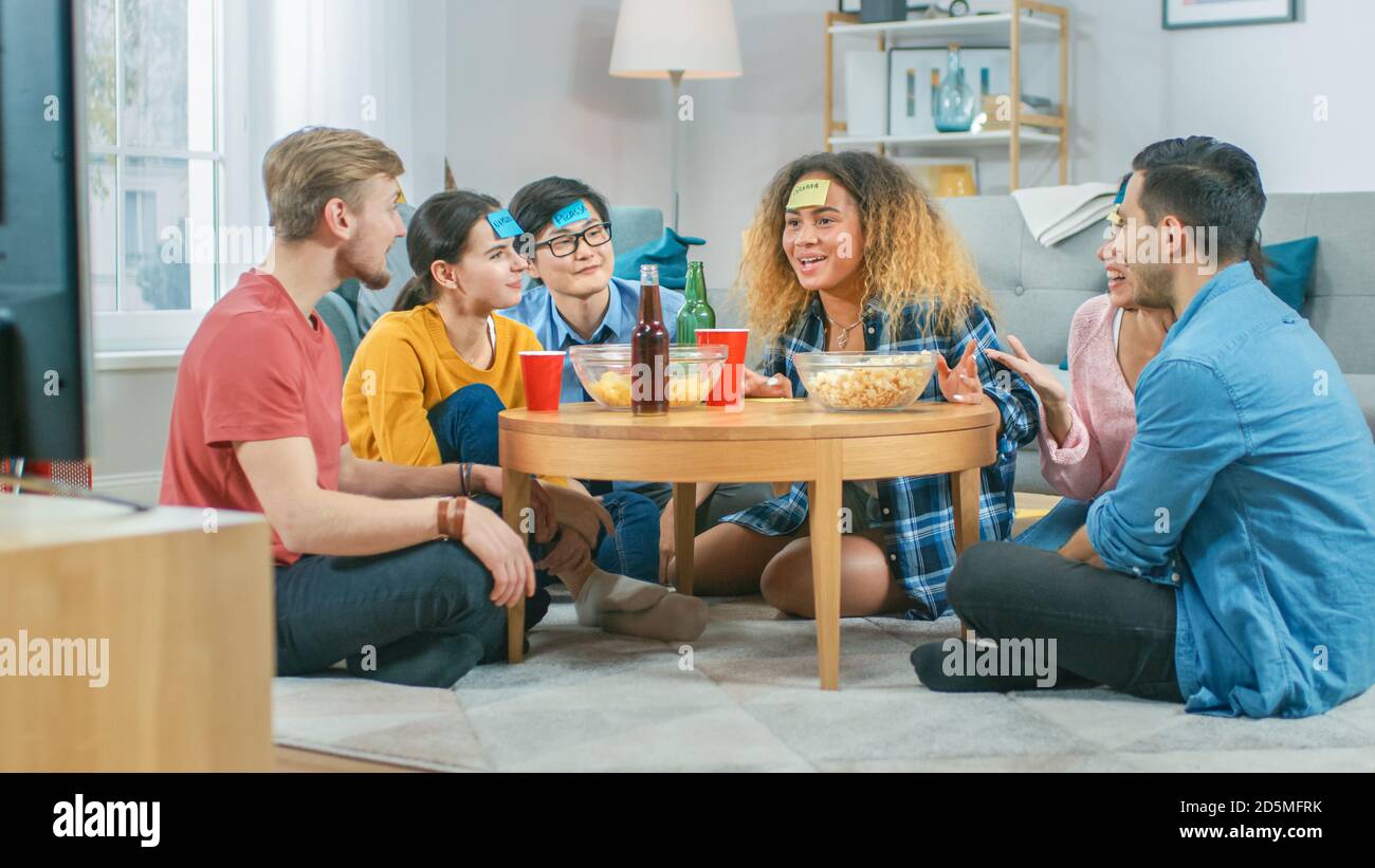 In the Living Room Diverse Group of Fun Loving Friends Playing "Who am ...