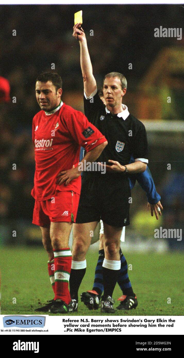 Referee Neal Barry shows Swindon's Gary Elkin the yellow card moments ...