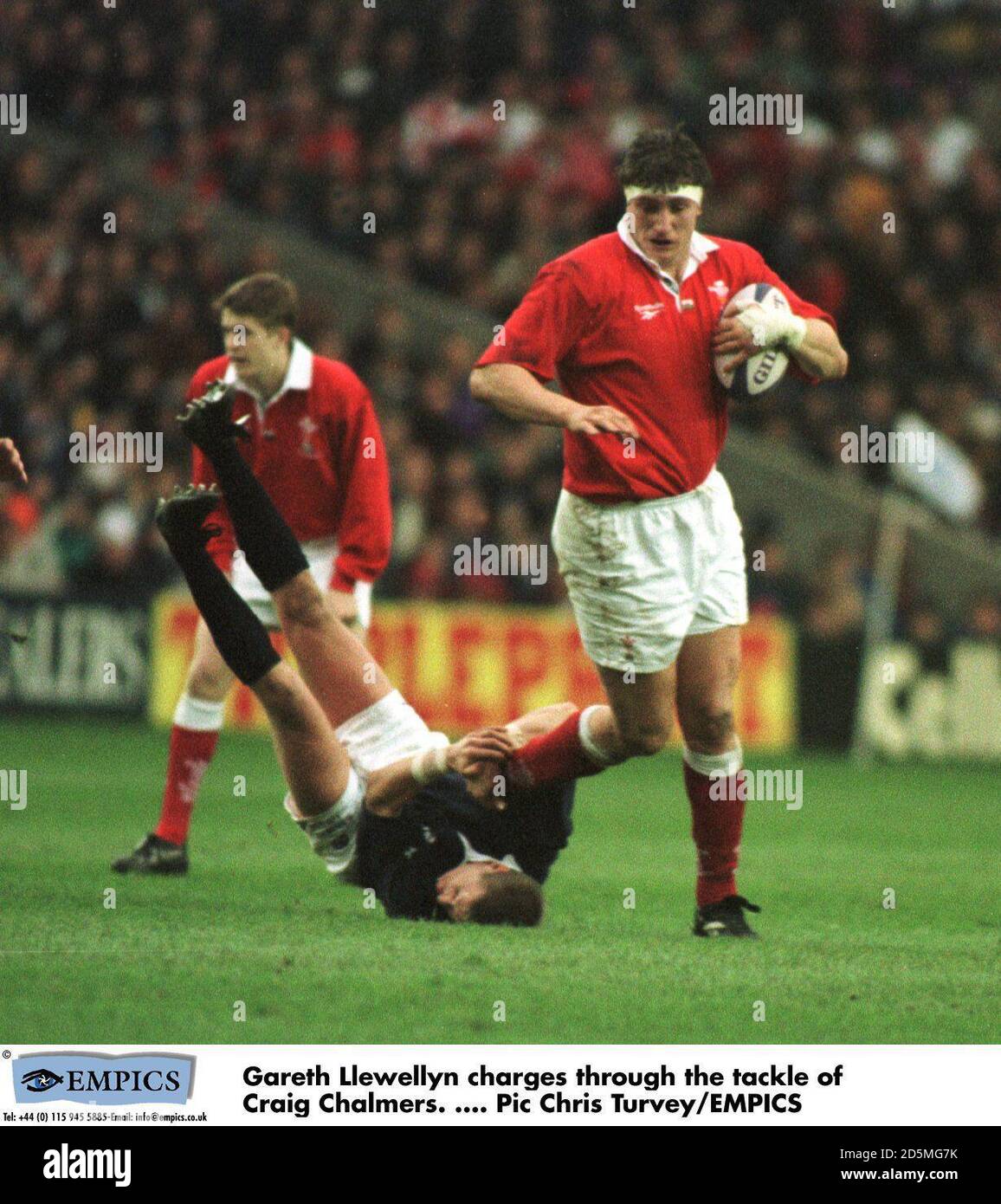 Gareth Llewellyn charges through the tackle of Craig Chalmers Stock ...