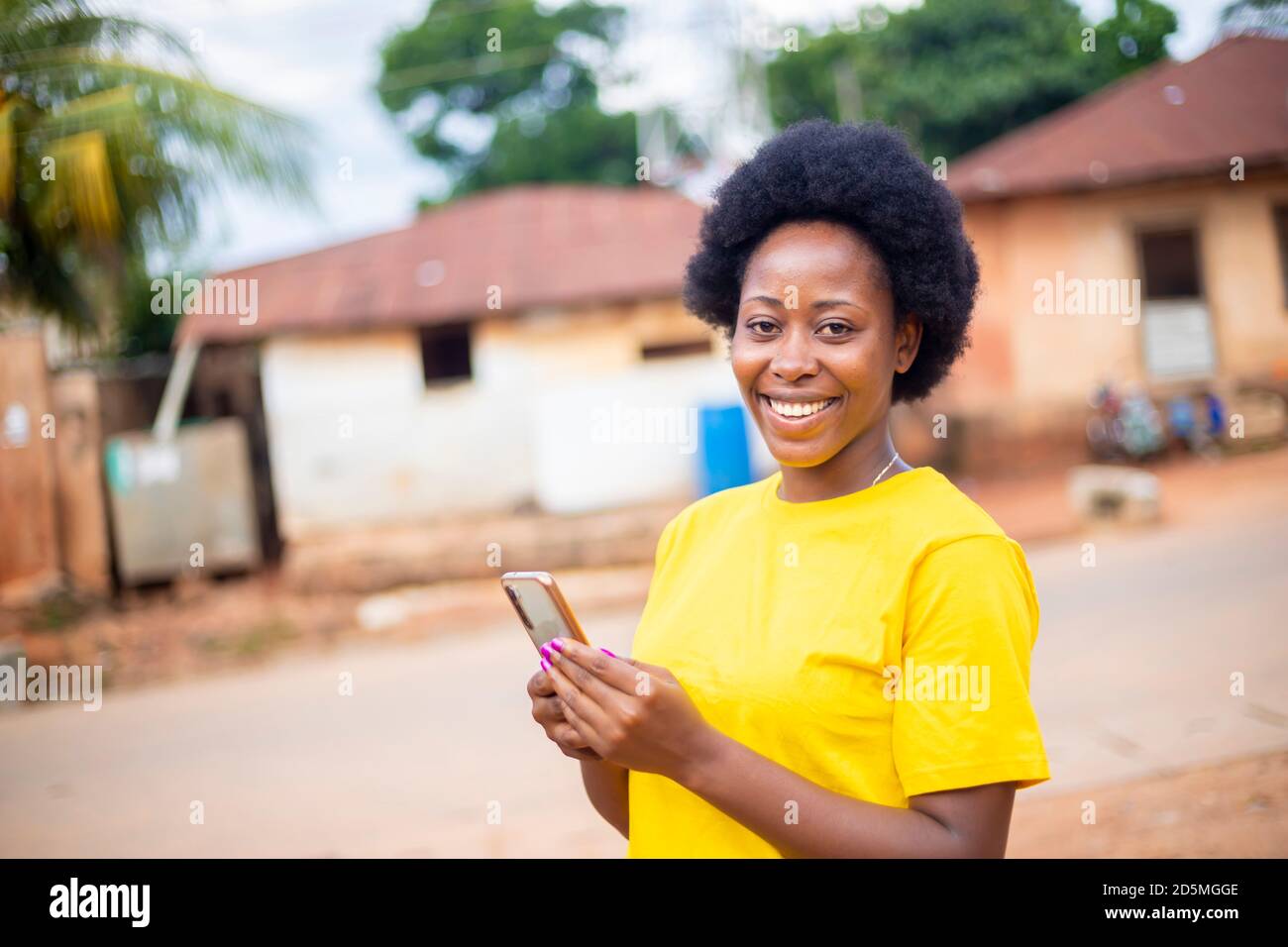 Young black African woman using mobile phone standing outside Stock ...