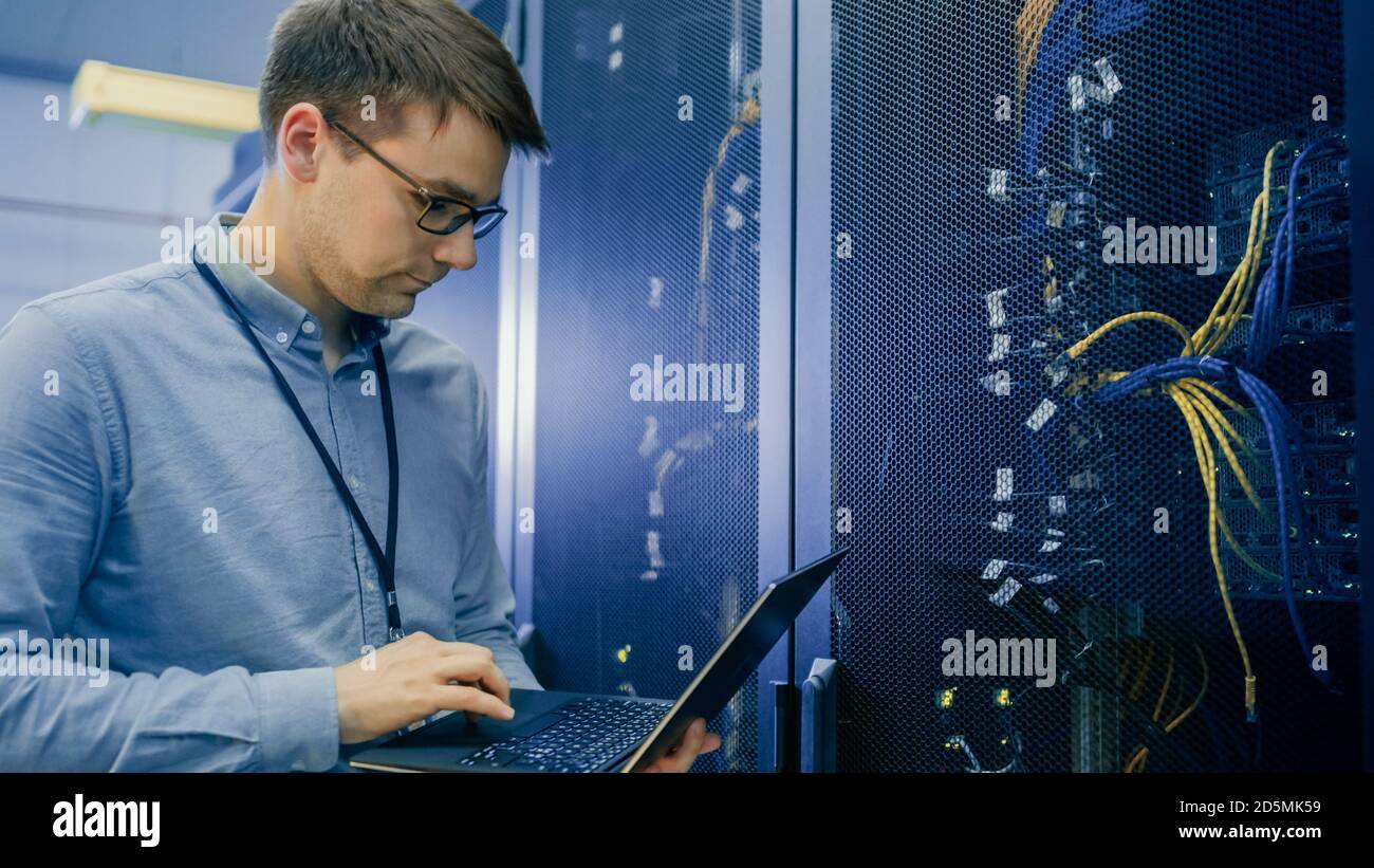 In Data Center IT Engineer Stands Before Working Server Rack Doing ...