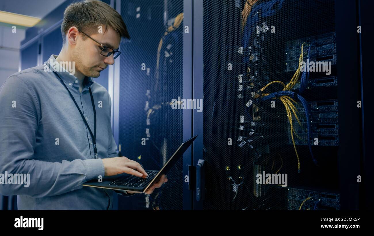 In Data Center IT Engineer Stands Before Working Server Rack Doing ...