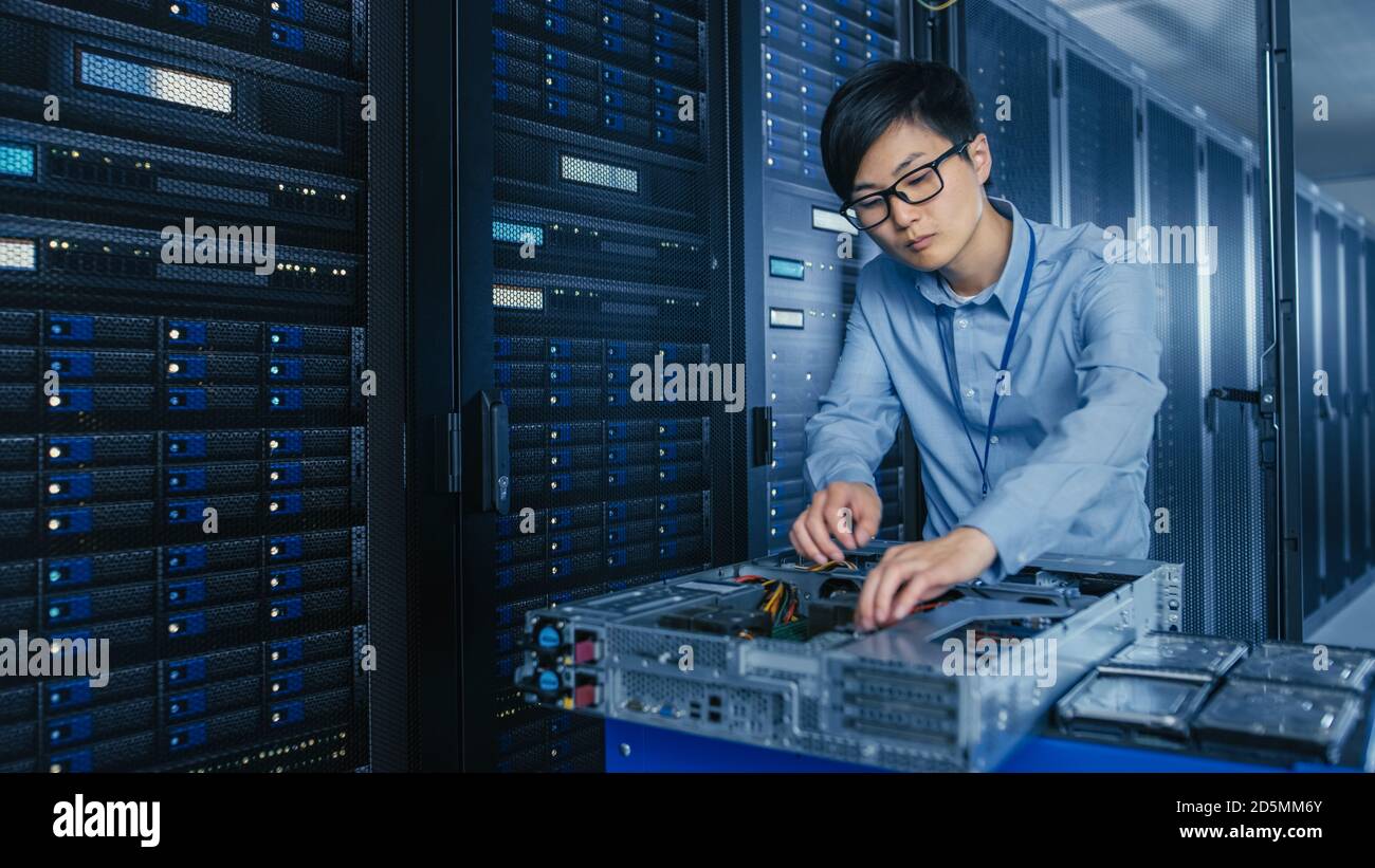 In the Modern Data Center: IT Technician Working with Server Racks, on ...