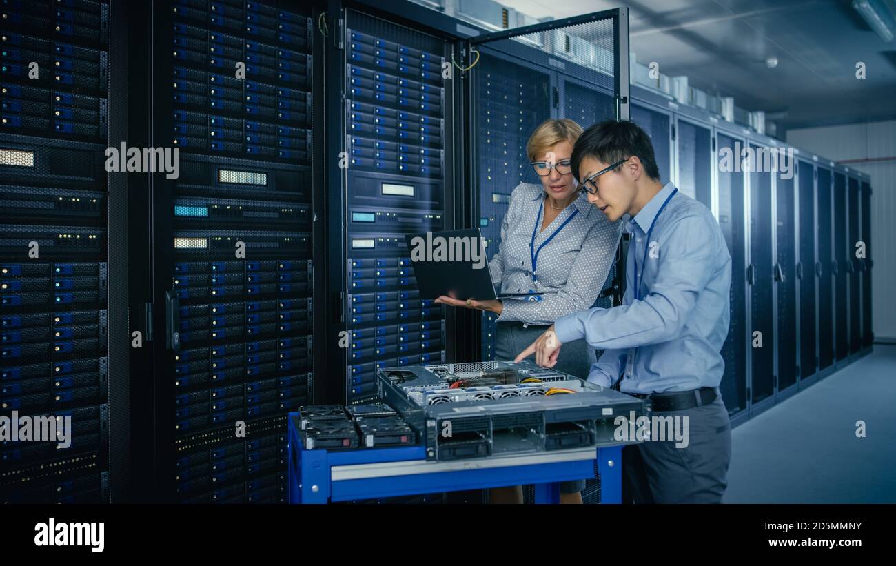 In the Modern Data Center: Engineer and IT Specialist Work with Server ...