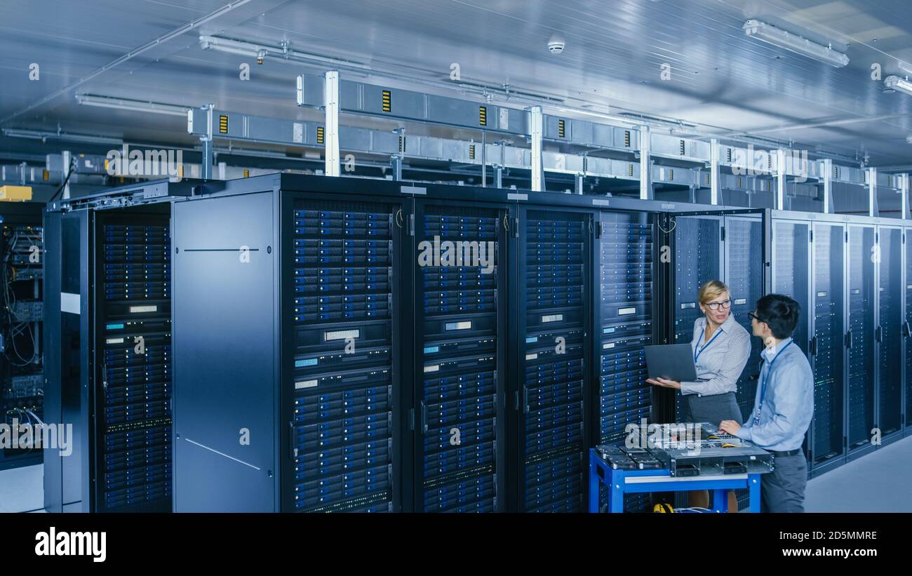 In the Modern Data Center: Engineer and IT Specialist Work with Server ...