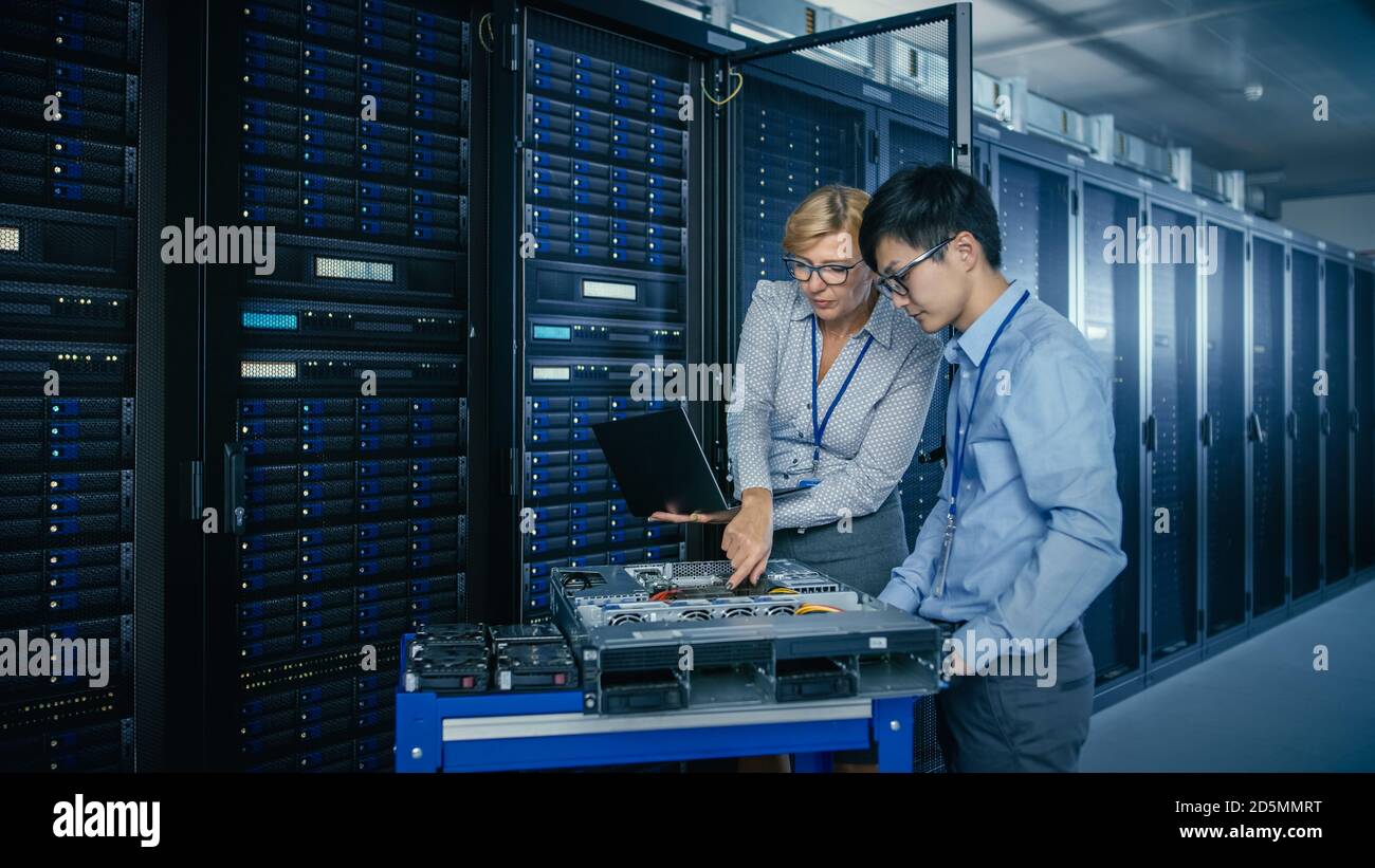 In the Modern Data Center: Engineer and IT Specialist Work with Server ...