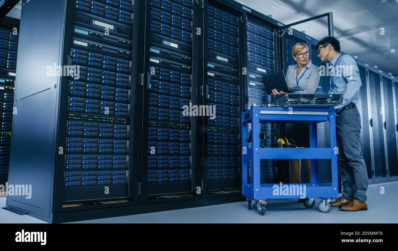 In the Modern Data Center: Engineer and IT Specialist Work with Server ...