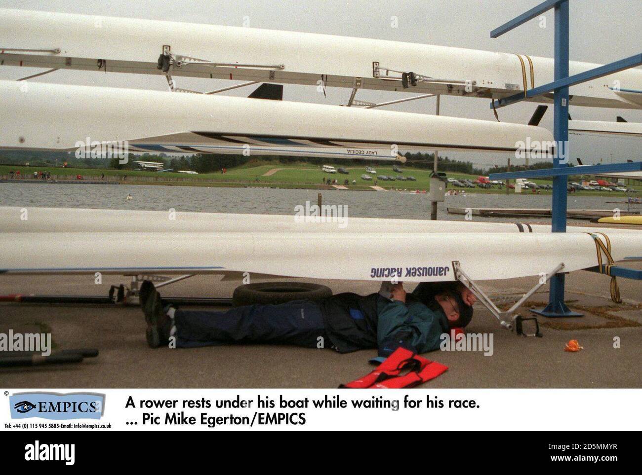 A rower rests under his boat while waiting for his race Stock Photo - Alamy