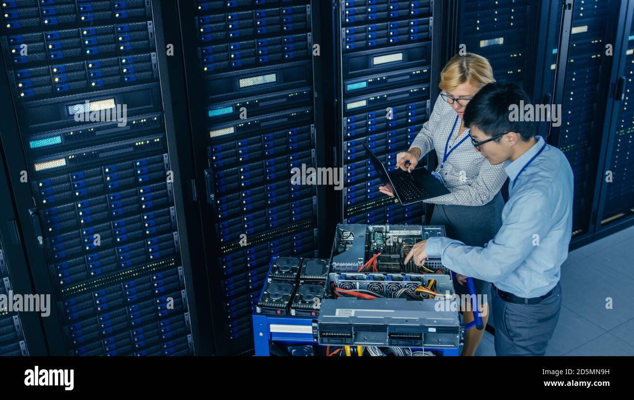 In the Modern Data Center: Engineer and IT Specialist Work with Server ...
