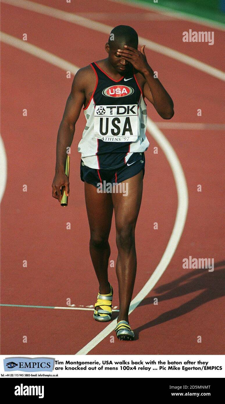 Tim Montgomery, USA walks back with the baton after they are knocked ...