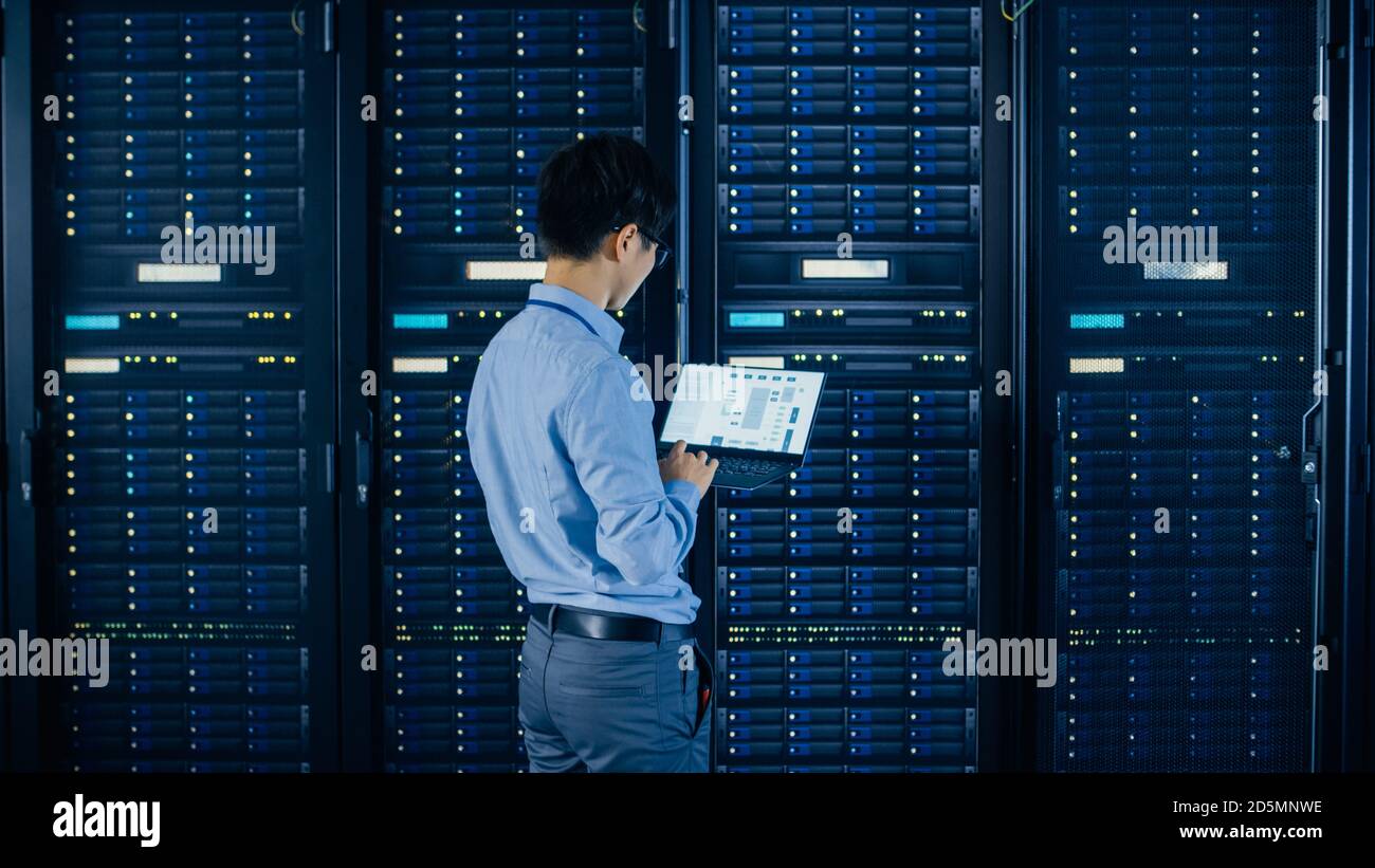 In the Modern Data Center: IT Engineer Standing Beside Open Server Rack ...