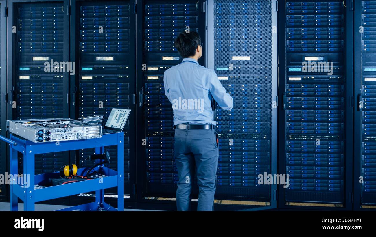 In the Modern Data Center: IT Engineer Doing Maintenance and ...