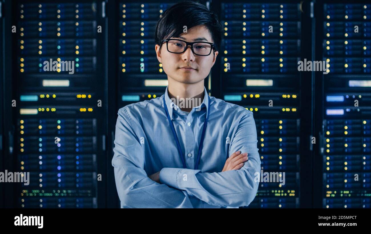 In the Modern Data Center: Portrait of IT Engineer Standing with Server ...