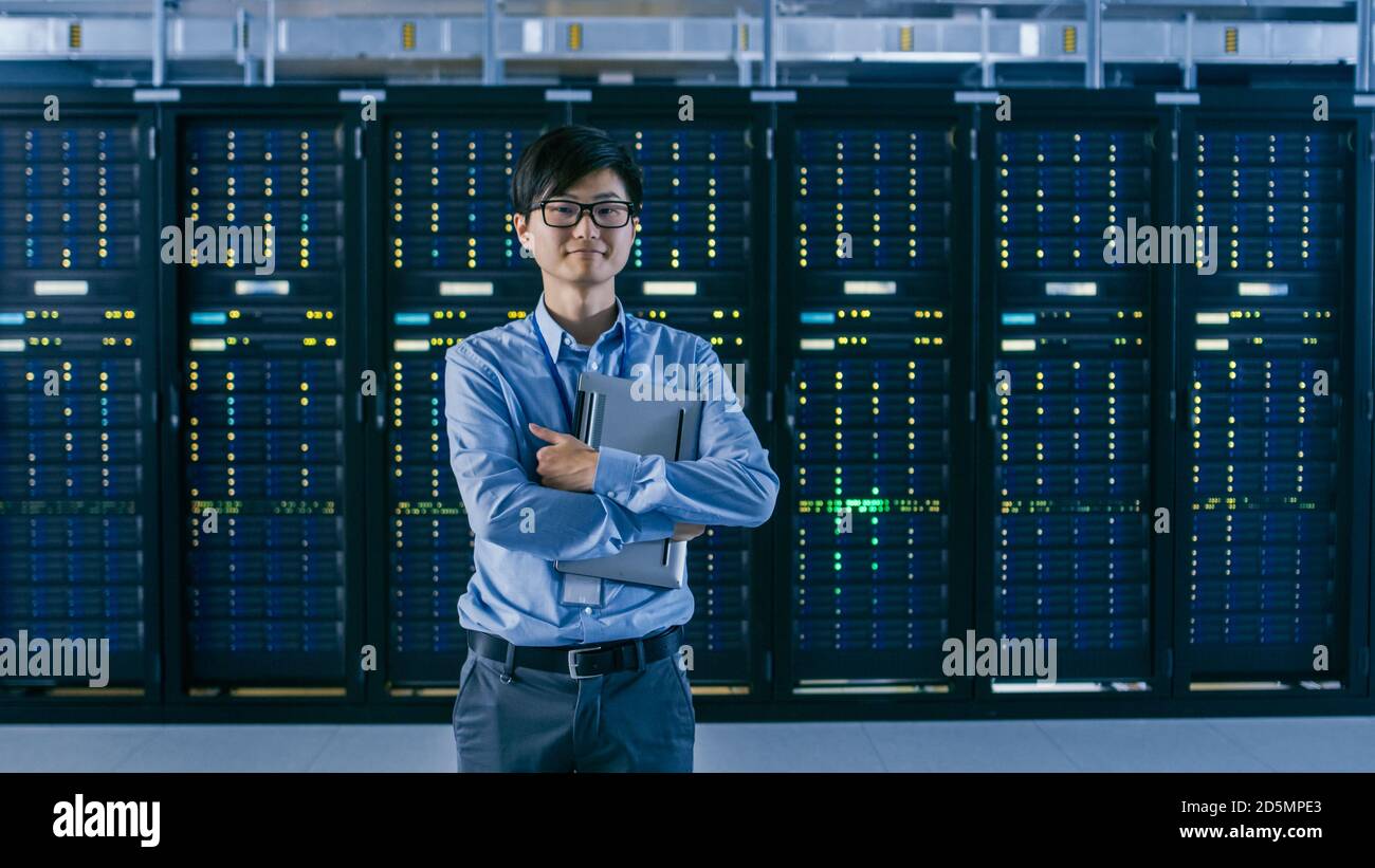 In the Modern Data Center: Portrait of IT Engineer Standing with Server ...