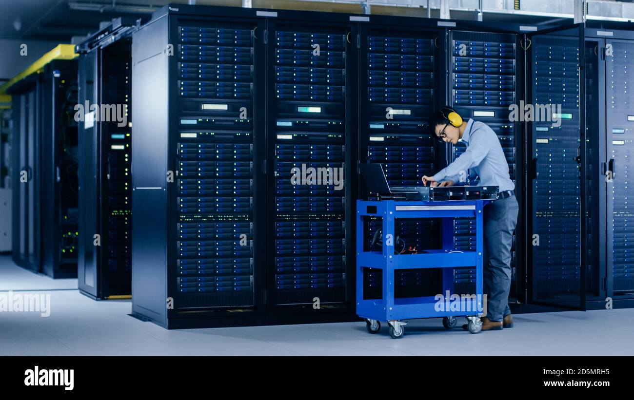 In Data Center: IT Engineer Wearing Protective Muffs Installs New ...