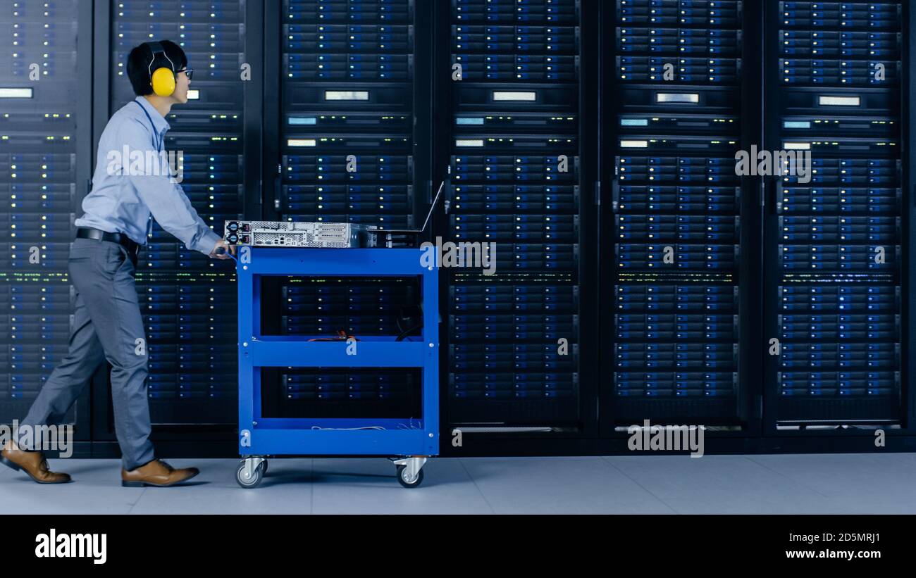 In the Modern Data Center: IT Engineer Doing Maintenance and ...